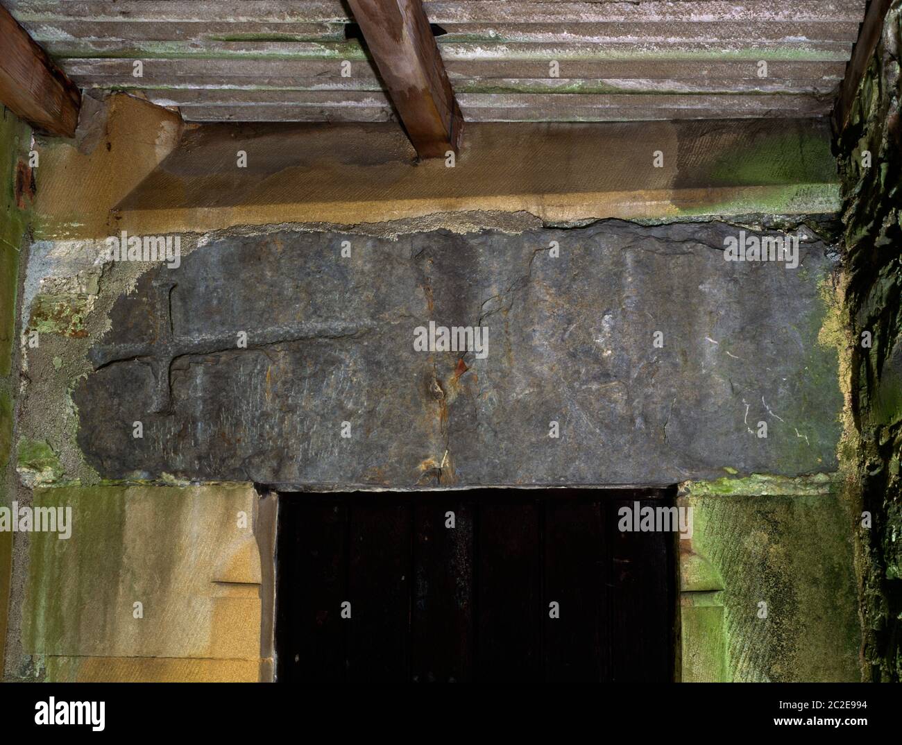 A C7th-C9th cross-carved stone reused as the lintel over the S chancel ...