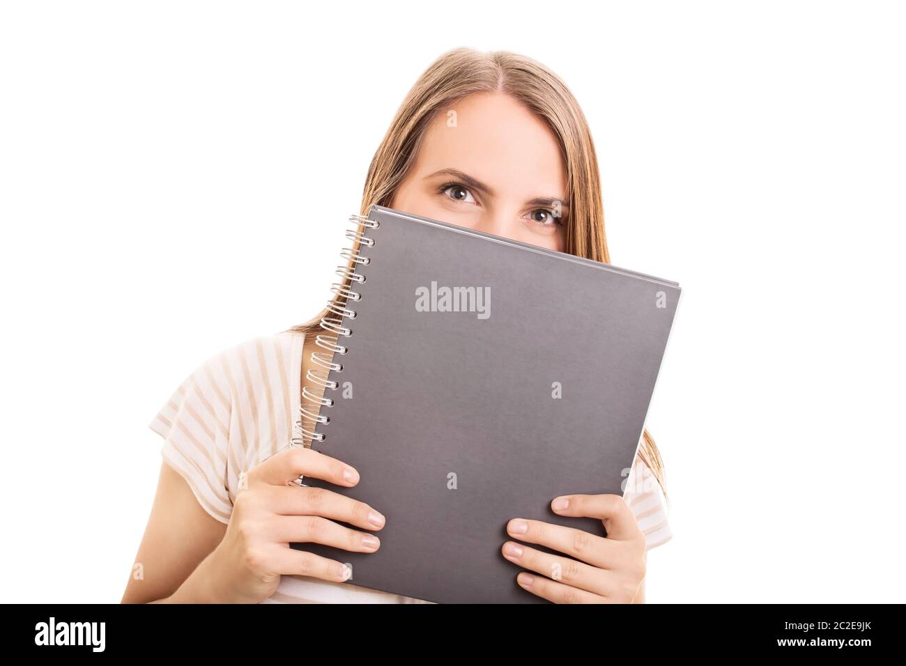 Beautiful girl hiding her smile behind a notebook, isolated on white ...