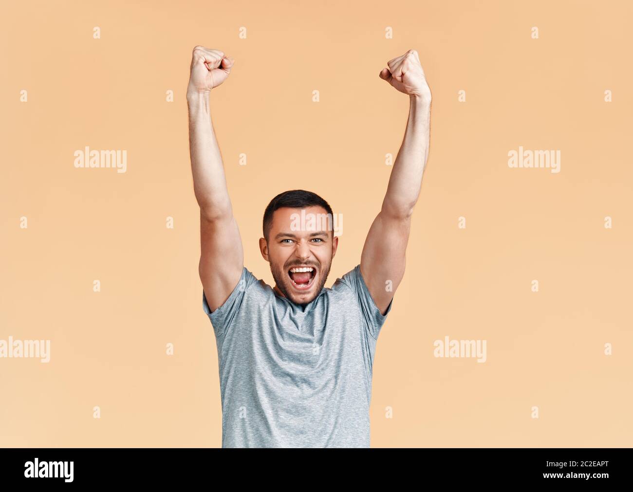 Happy man celebrating his success with winner gesture and hands up ...