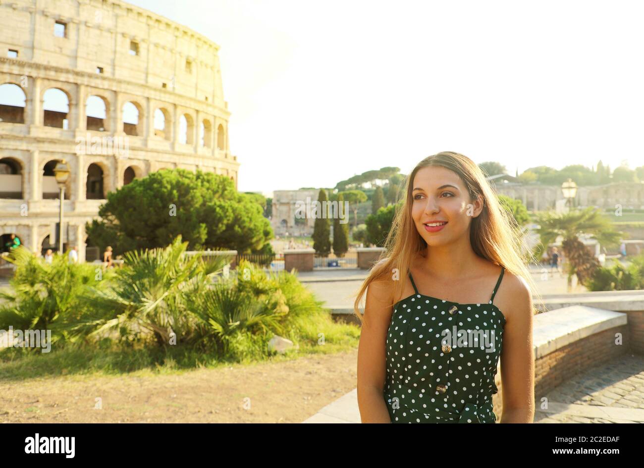 Portrait of smiling beautiful girl in Rome with Colosseum on the ...