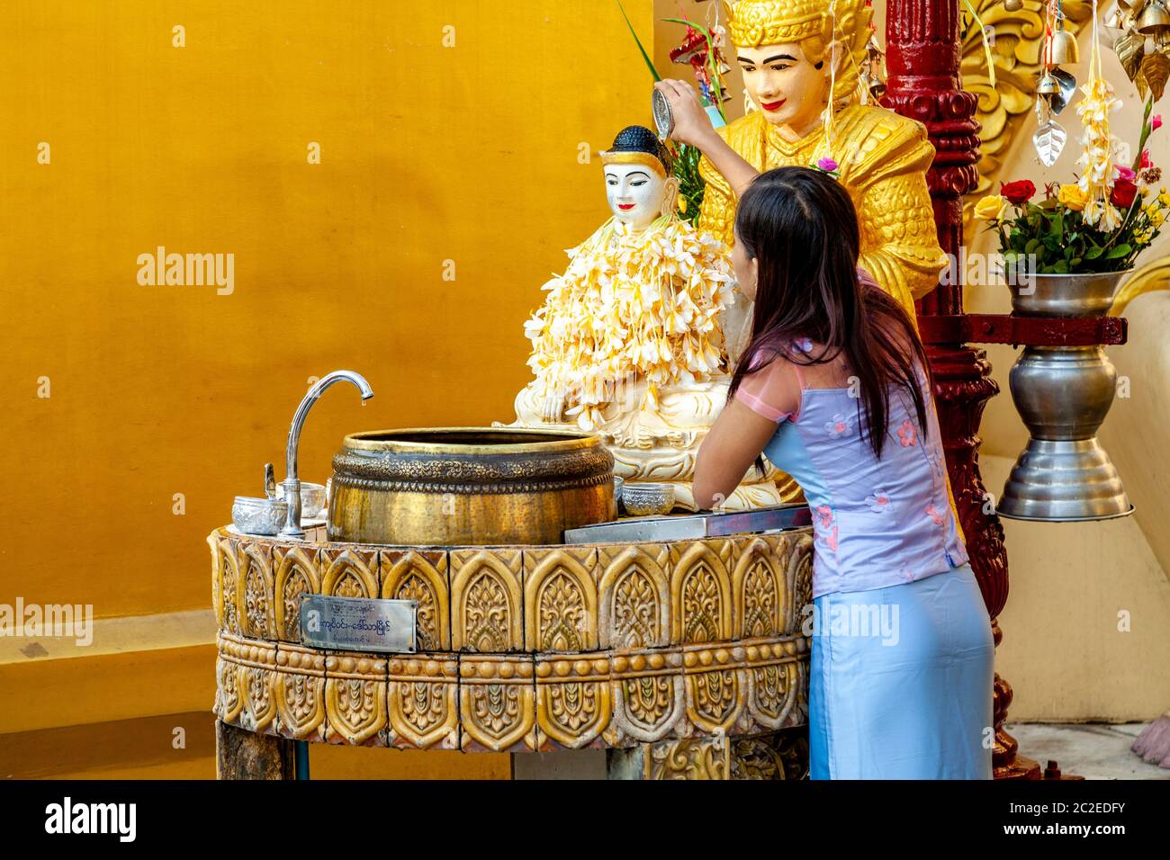 A Young Burmese Woman Bathing The Buddha At The Shwedagon Pagoda ...