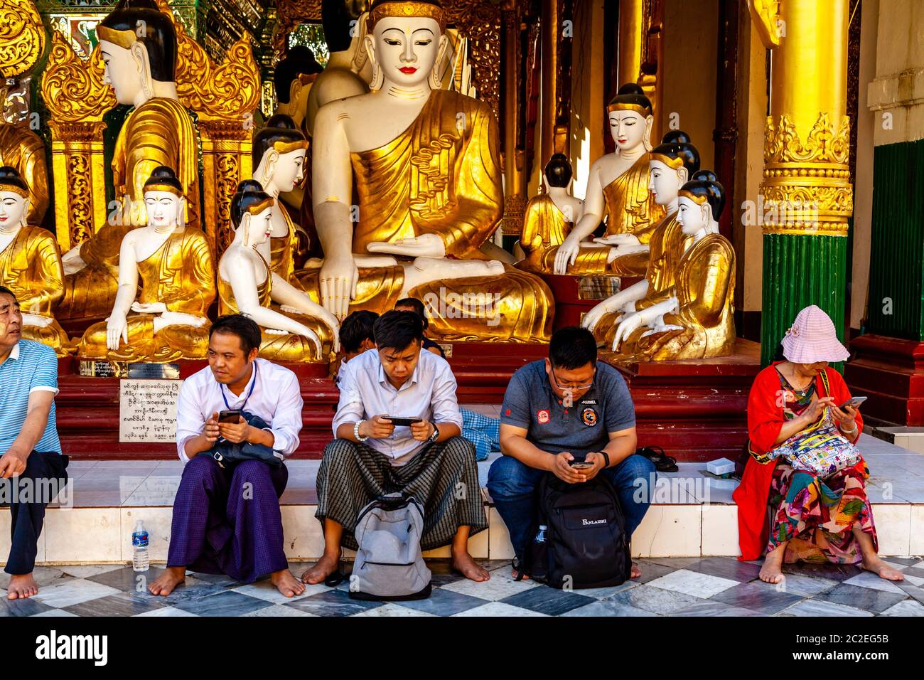 Visitors To The Shwedagon Pagoda Sitting Down Using Their Mobile Phones ...