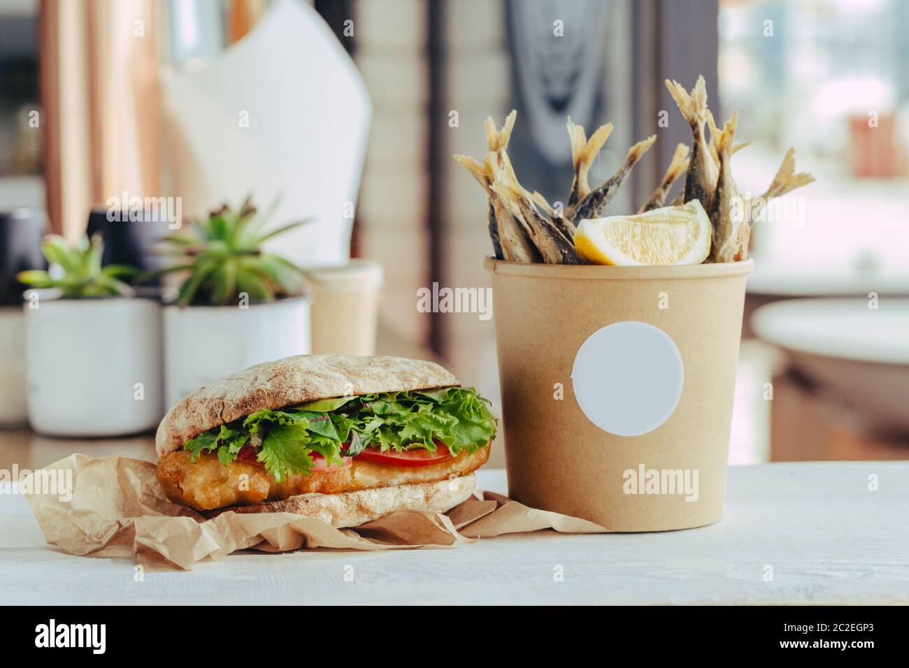 fried fish on a bun with lettuce, tomato street food Stock Photo - Alamy