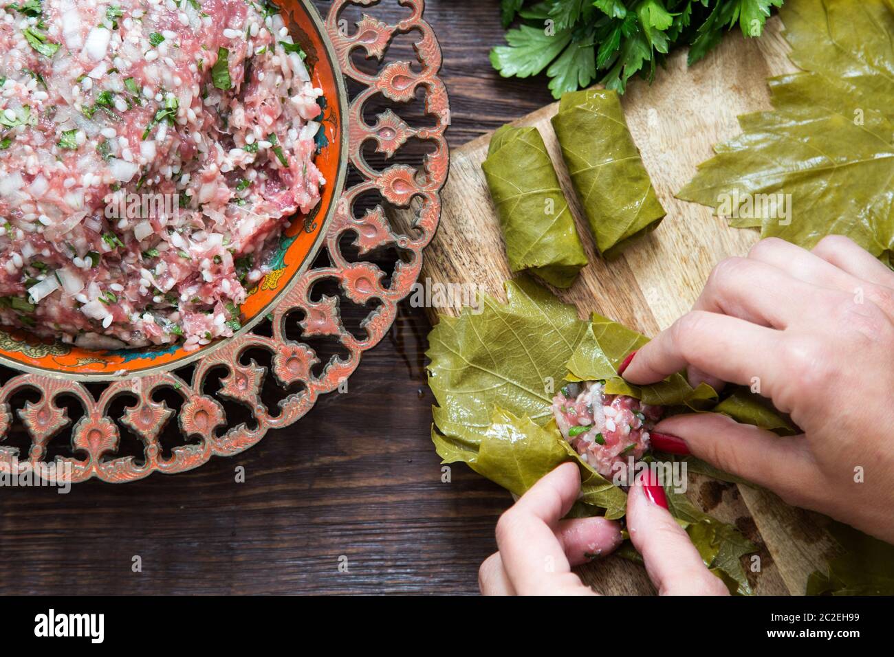 preparing stuffed vine leaves with rice and meat, or traditional Dolma ...
