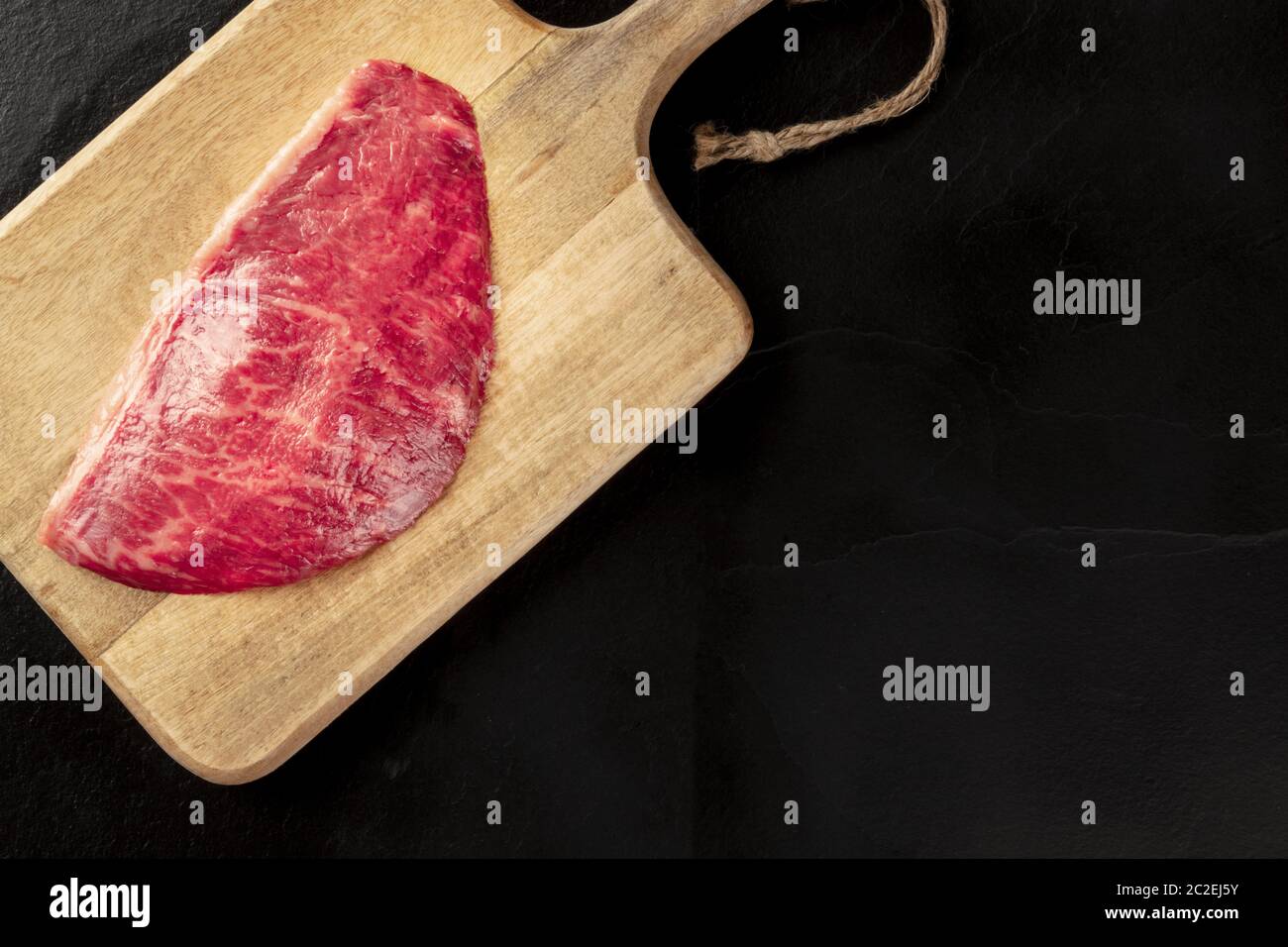 Kobe meat, wagyu beef steak, raw, overhead shot on a cutting board on a ...