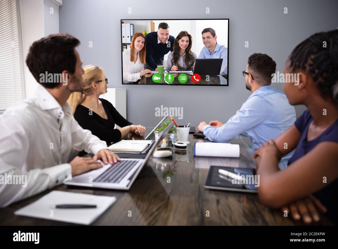 Businesspeople Sitting In A Conference Room Looking At Computer Screen ...