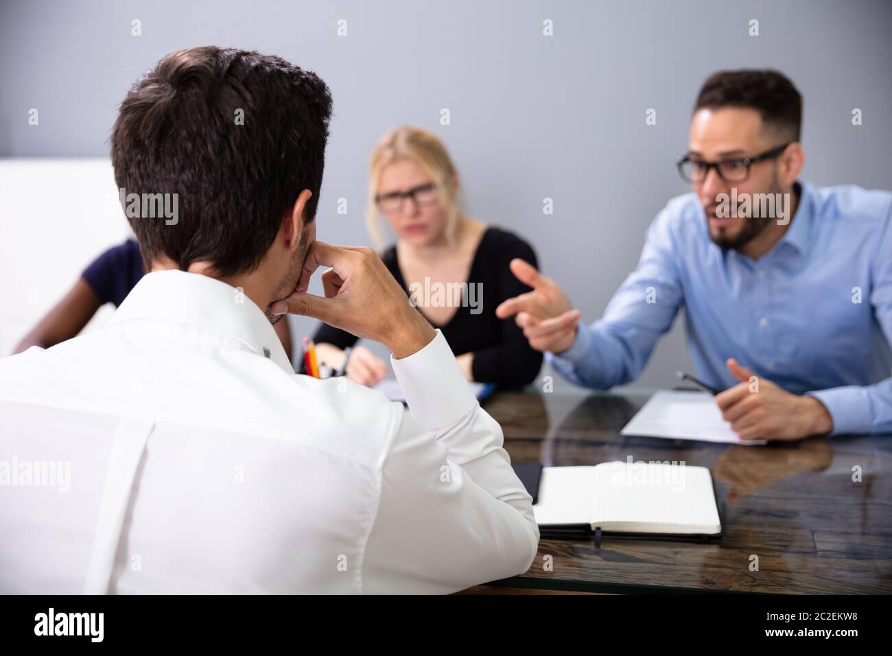 Business People Sitting At Table In Meeting Room Conducting Job ...
