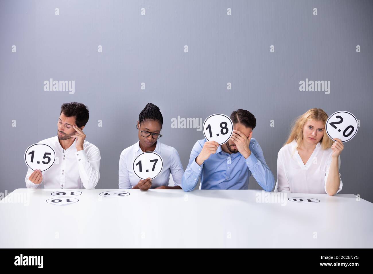 Disappointed Business People Showing Low Score Cards Sitting Against ...