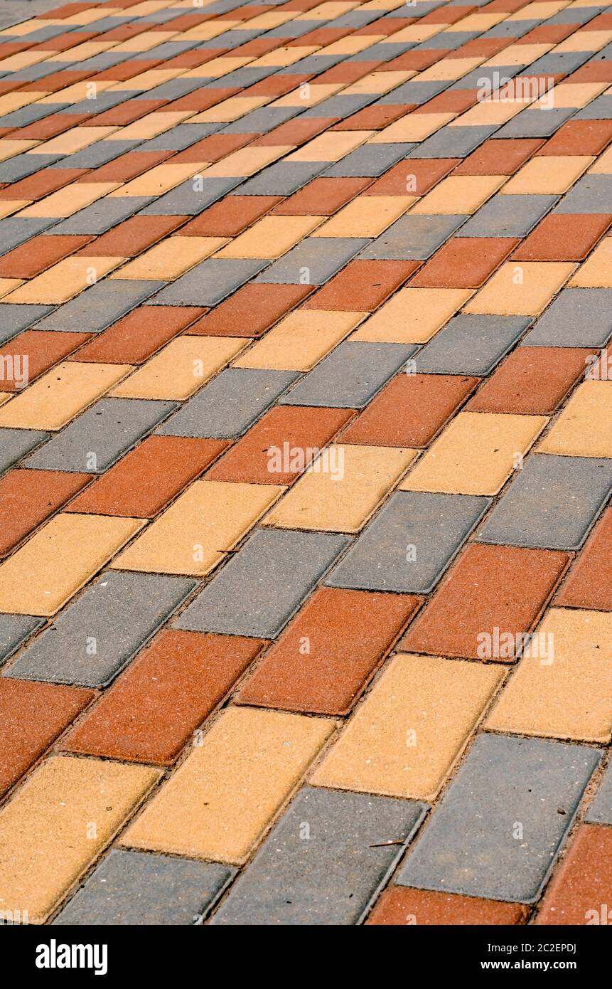 City street paved with three-color paving slabs. Sidewalk with gray ...