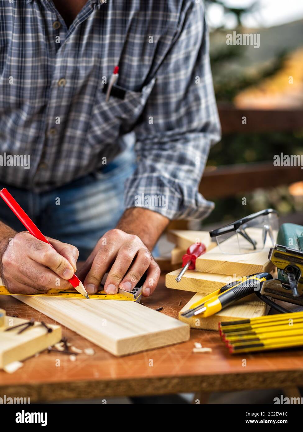 Craftsman adult carpenter with a pencil and the joiner's team trace the ...