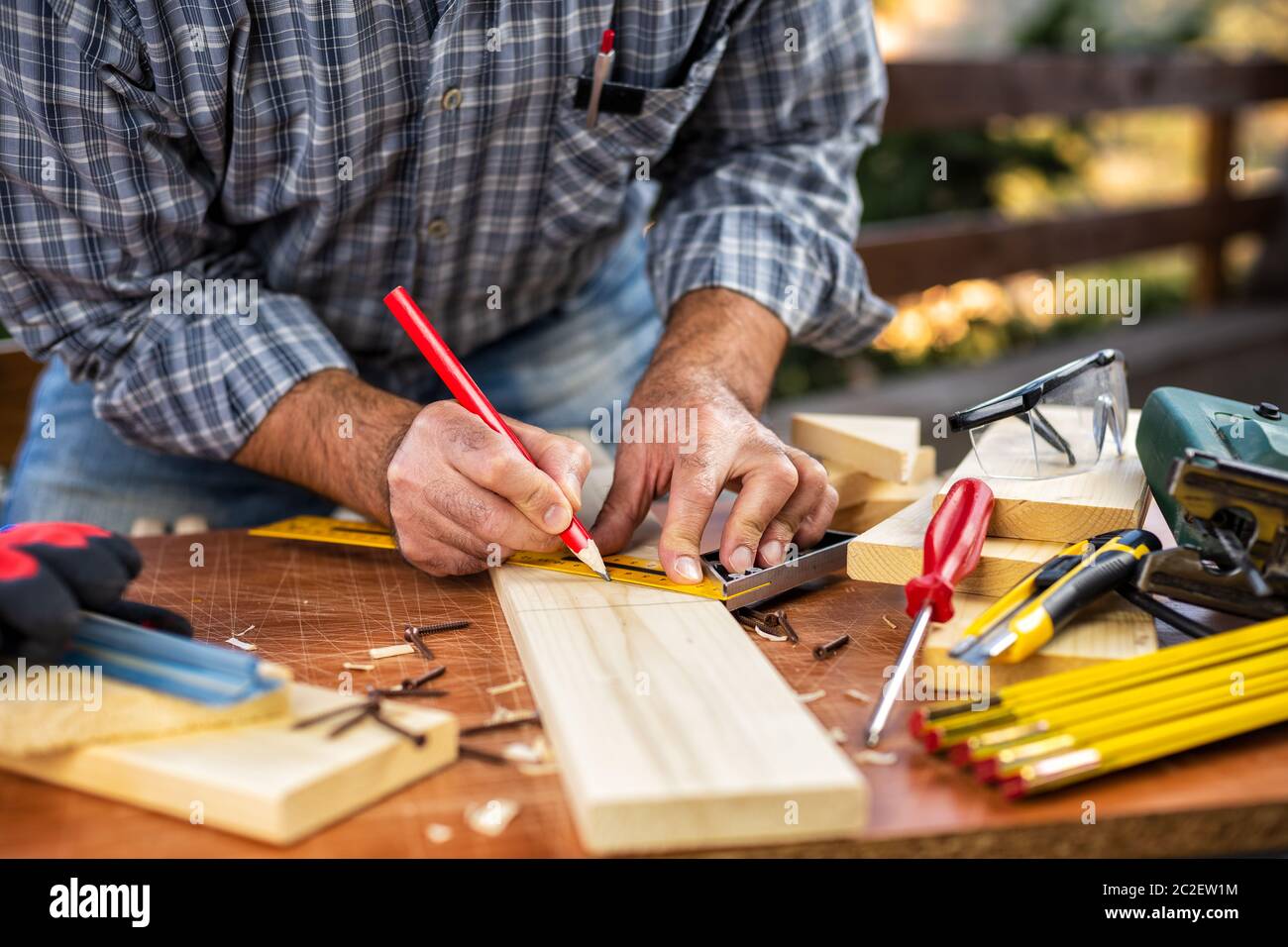 Craftsman adult carpenter with a pencil and the joiner's team trace the ...