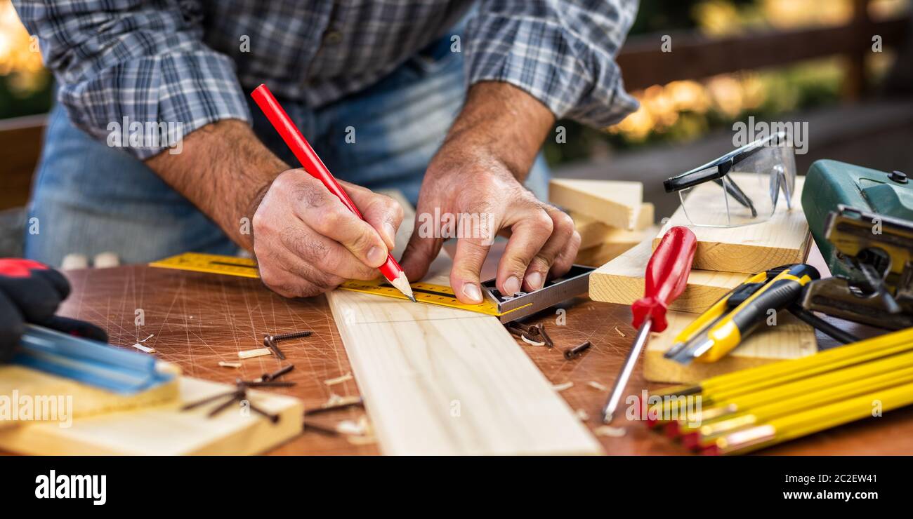 Craftsman adult carpenter with a pencil and the joiner's team trace the ...