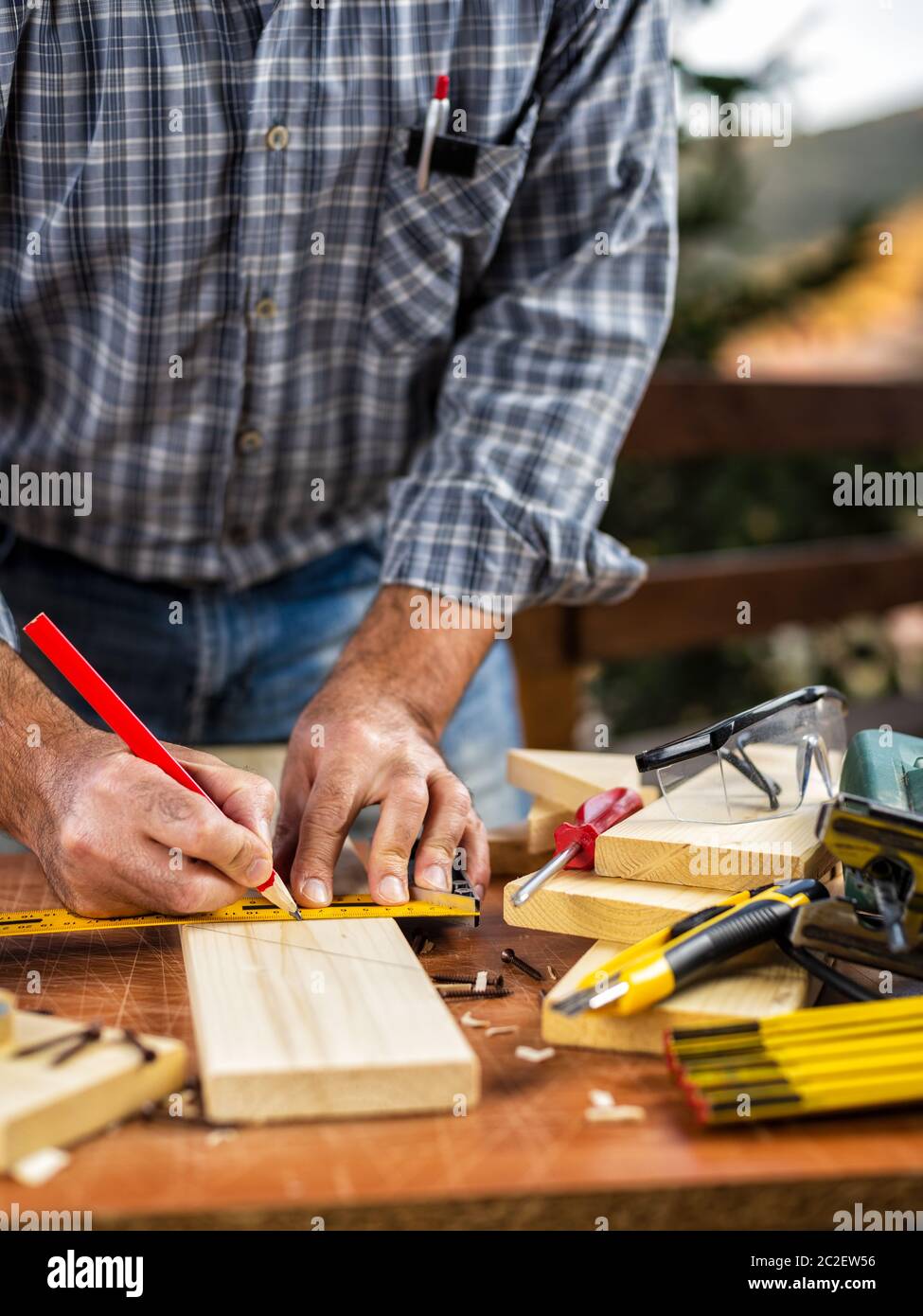 Craftsman adult carpenter with a pencil and the joiner's team trace the ...