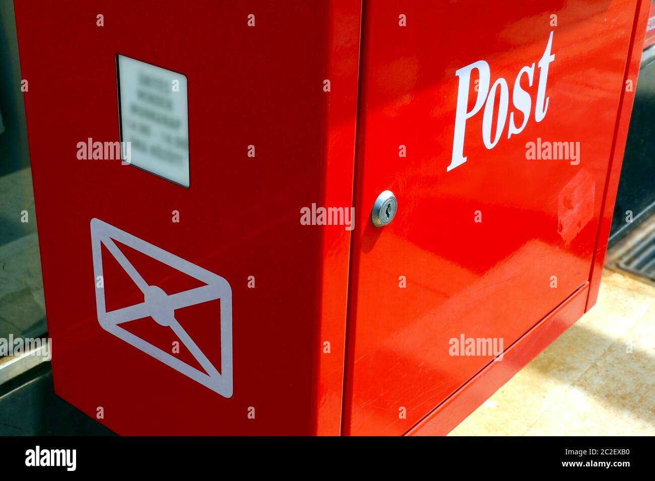 bright red metal mail collection box in bright daylight. depicting ...