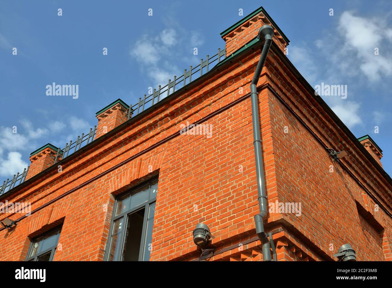 Building of bright orange brick on a background of blue sky in the ...