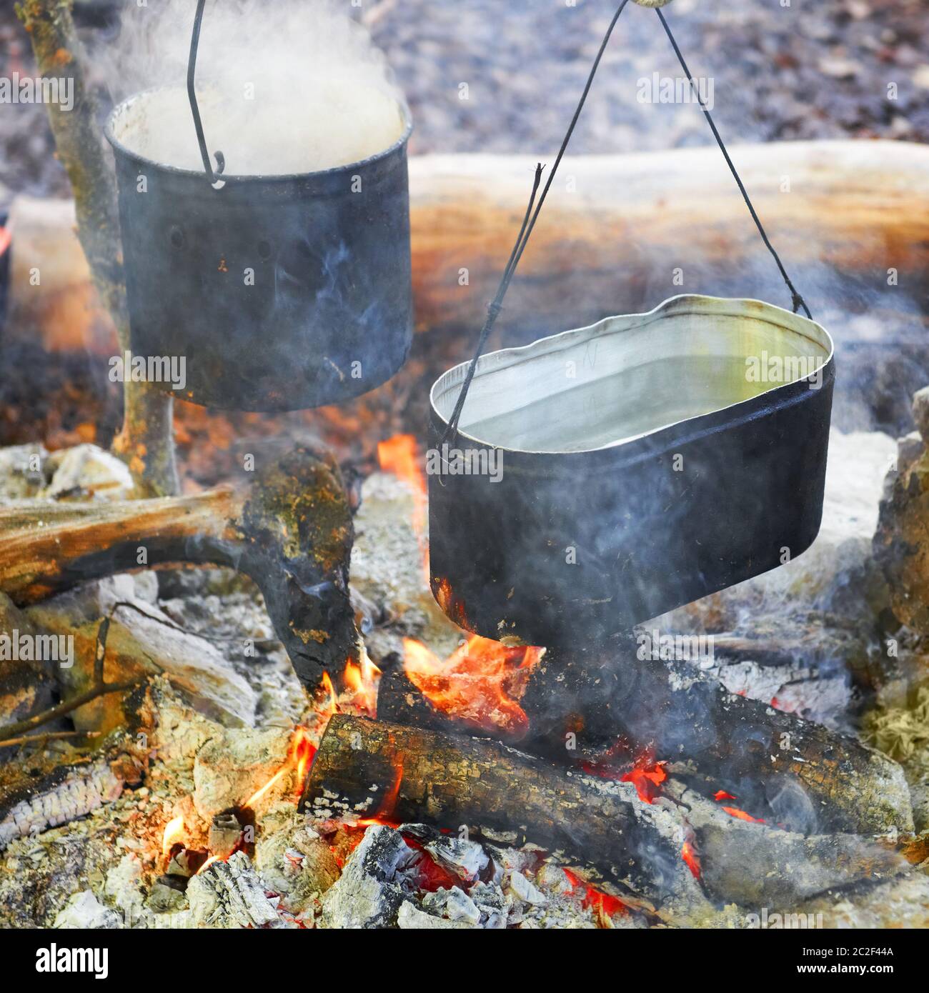 Boiling water in two pots above the fire Stock Photo - Alamy
