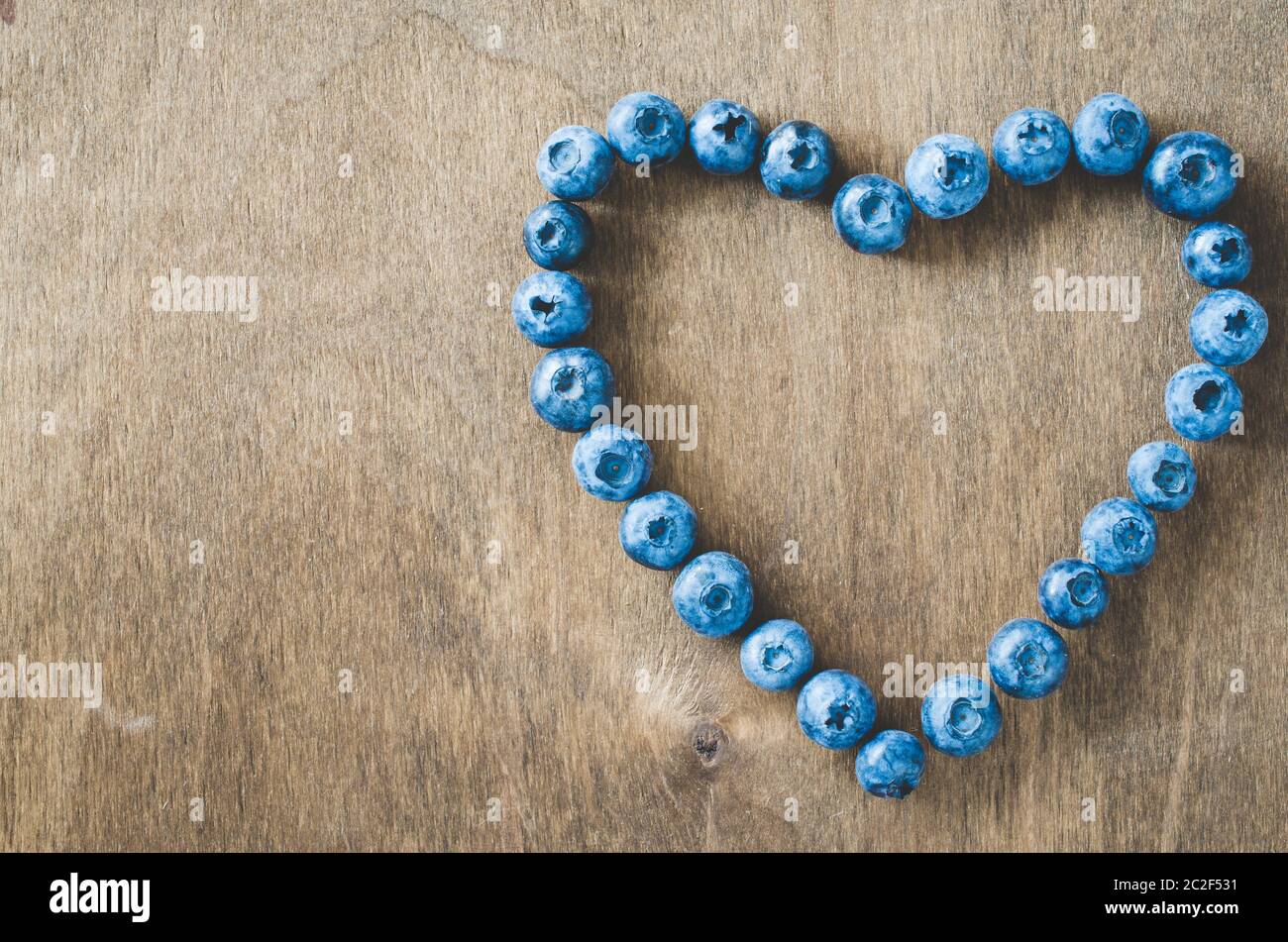 Fresh organic blueberries in form of heart on wooden background. Heart ...