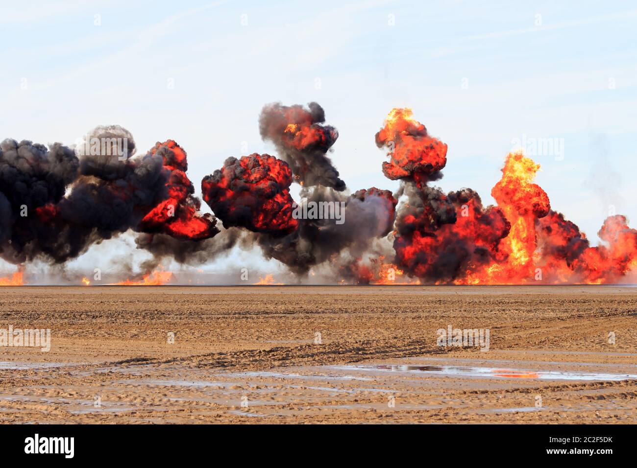 Multiple explosions on a sandy beach Stock Photo - Alamy