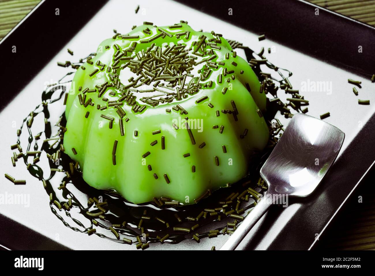 Green pudding sweet dessert from kiwi is served on black plate Stock ...