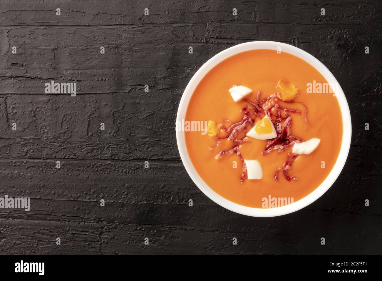 Salmorejo, Spanish cold tomato soup, overhead shot on a black ...