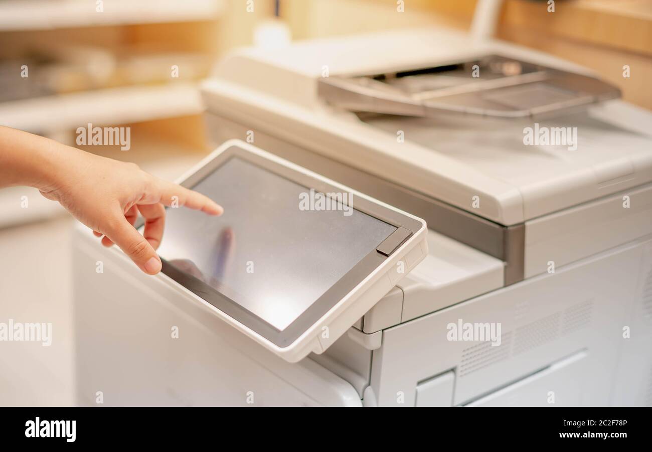 Female hand pressing the touchscreen monitor of the copy machine for ...