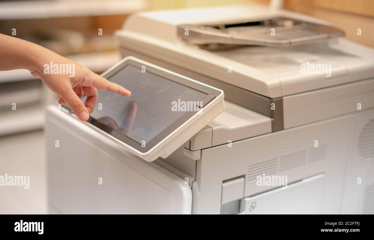 Female hand pressing the touchscreen monitor of the copy machine for ...