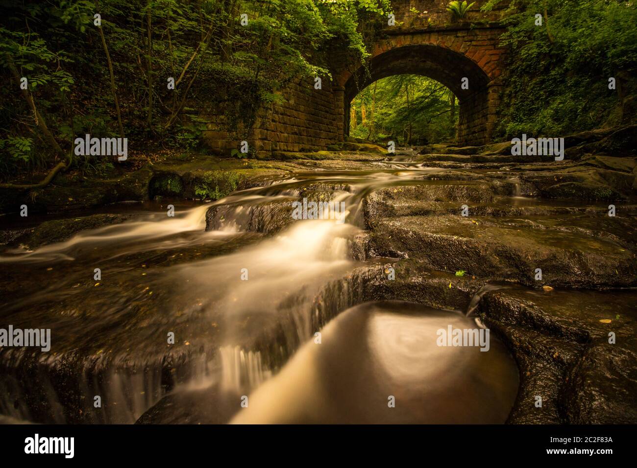 Small red brick bridge over the stream at falling foss waterfall ...