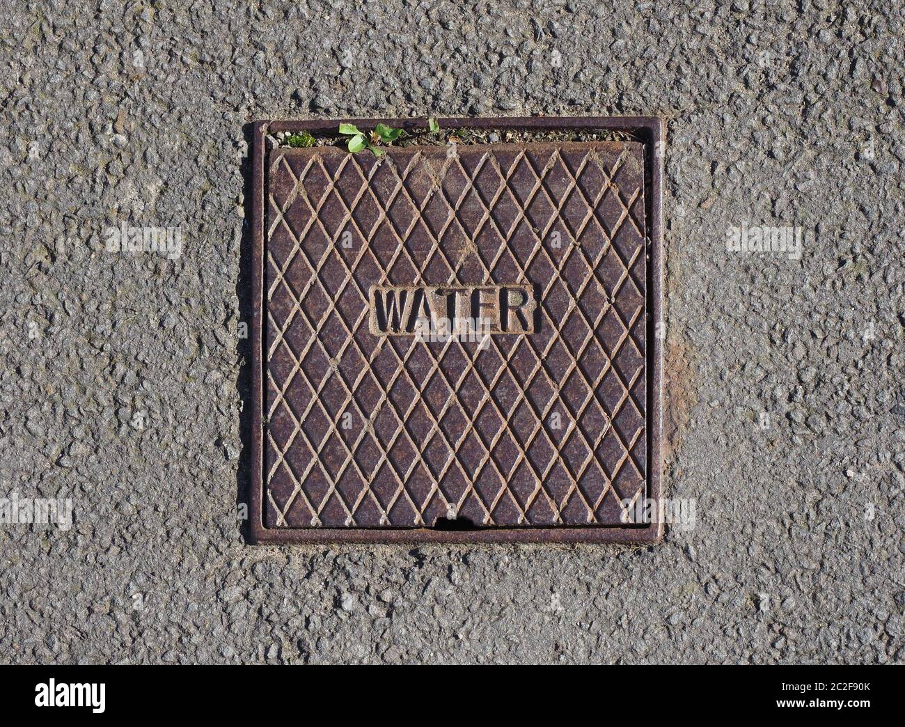 detail of a water service manhole in the roadway Stock Photo - Alamy