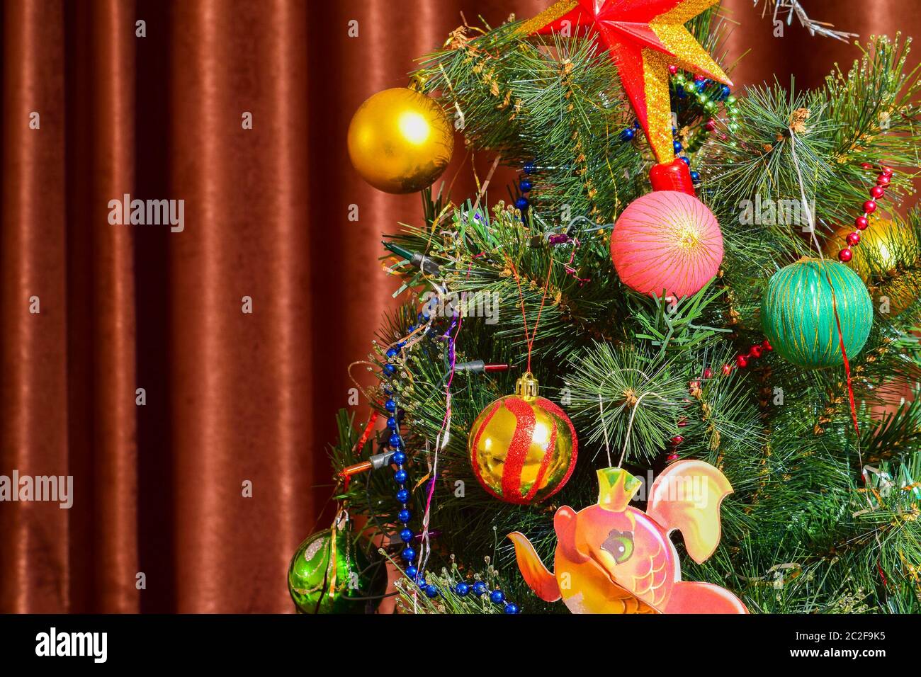 Christmas toys and ornaments on the Christmas tree. Tinsel, balls and ...