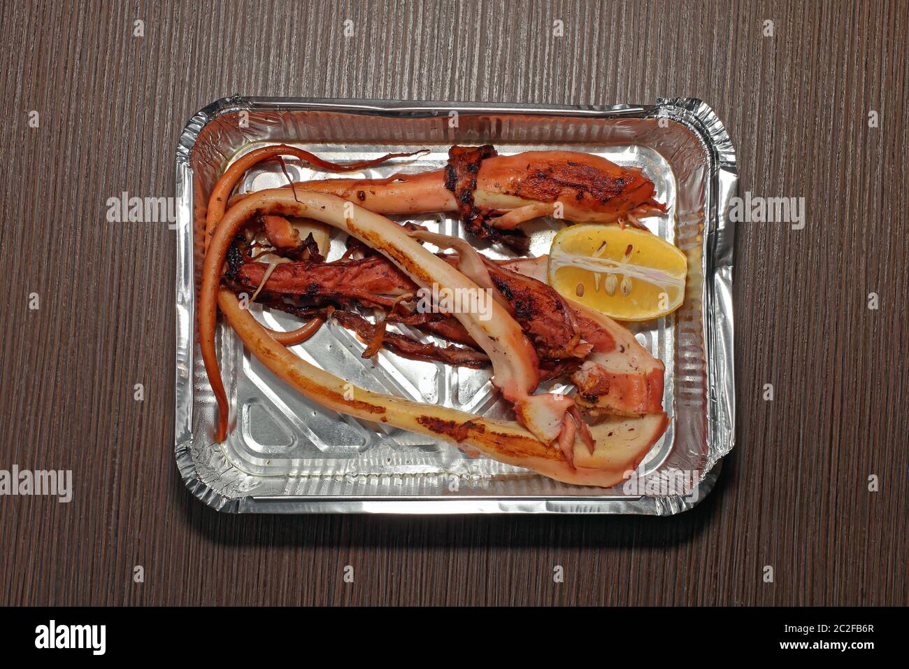 Grilled Octopus Arms With Lemon Seafood in Tray Stock Photo - Alamy