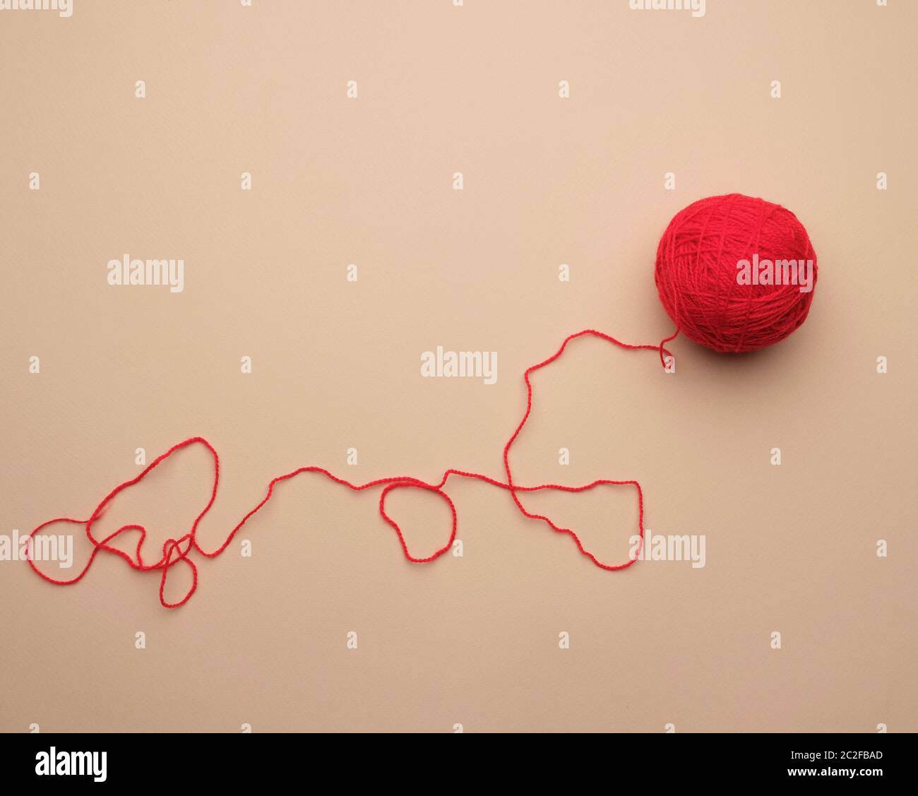 clew with red-woolen thread on a beige background, top view Stock Photo ...