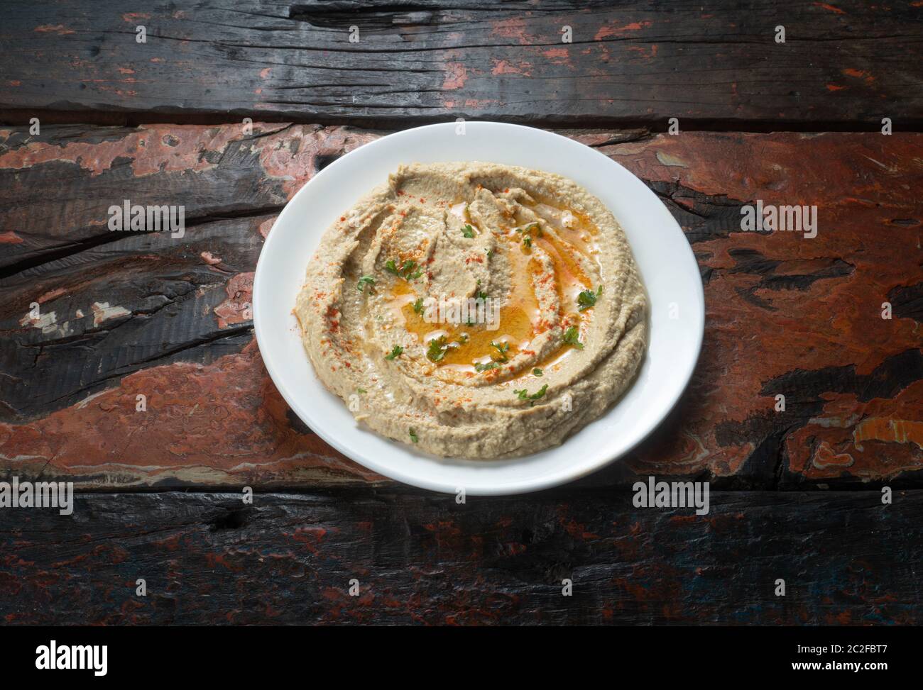 Delicious hummus on rustic wooden kitchen table. This is an Arab and ...