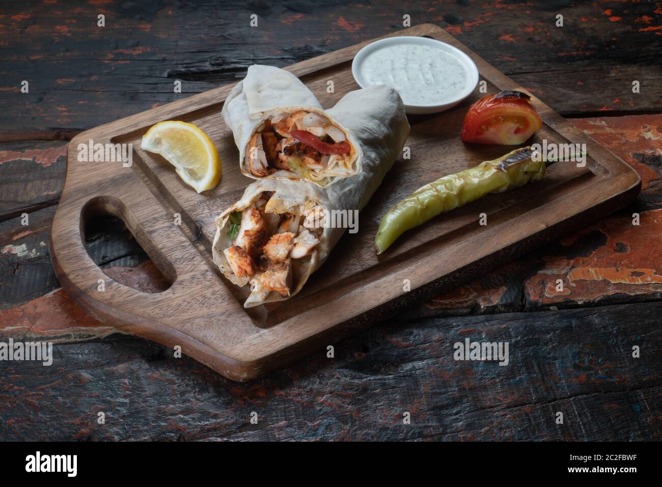 Chicken kebab roll wrap serving with yogurt and hot pepper isolated on ...