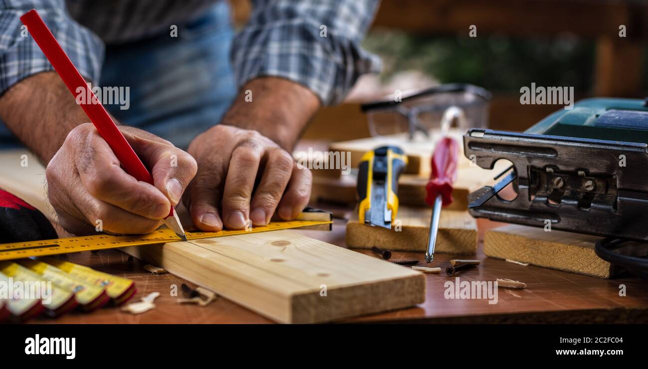 Adult carpenter craftsman with a pencil and the carpenter's square ...