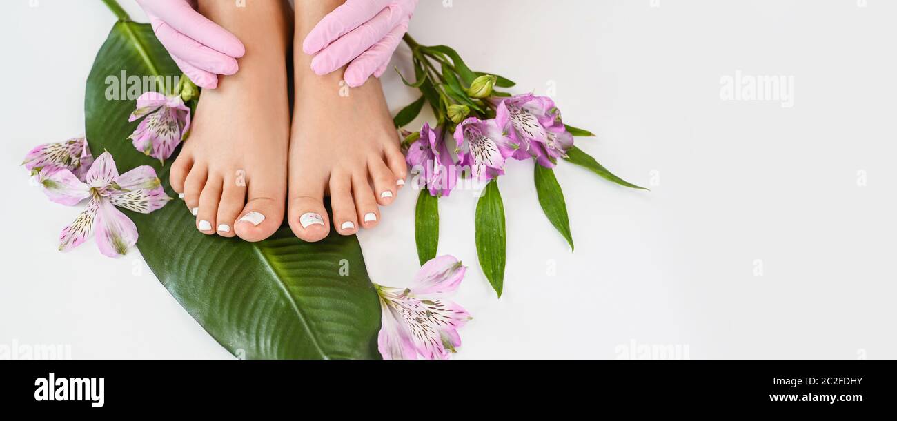 Beautiful perfect skin female legs feet top view with tropical flowers ...