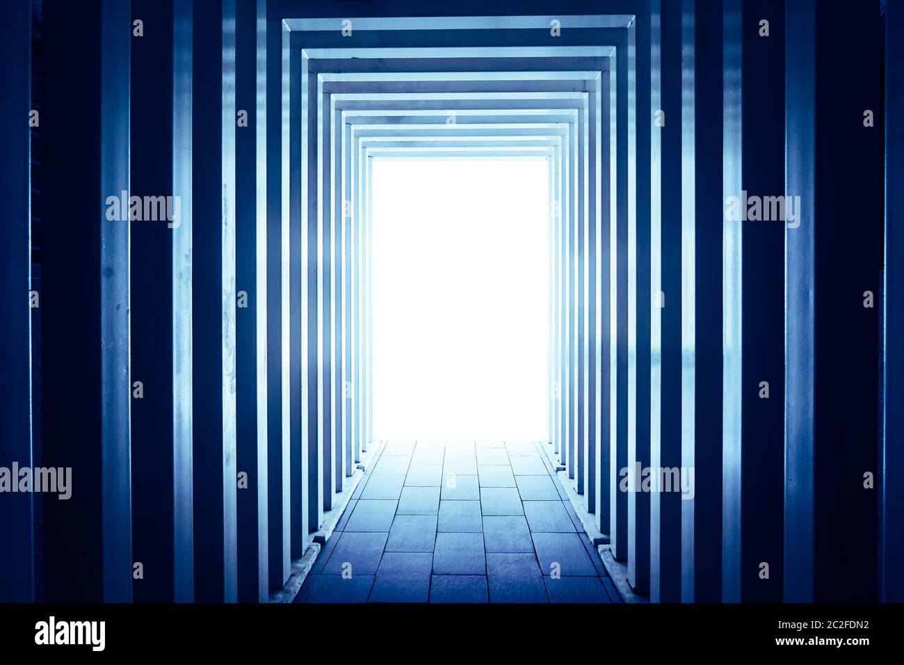 Line-shaped corridors leading to unknown bright exit door Stock Photo ...