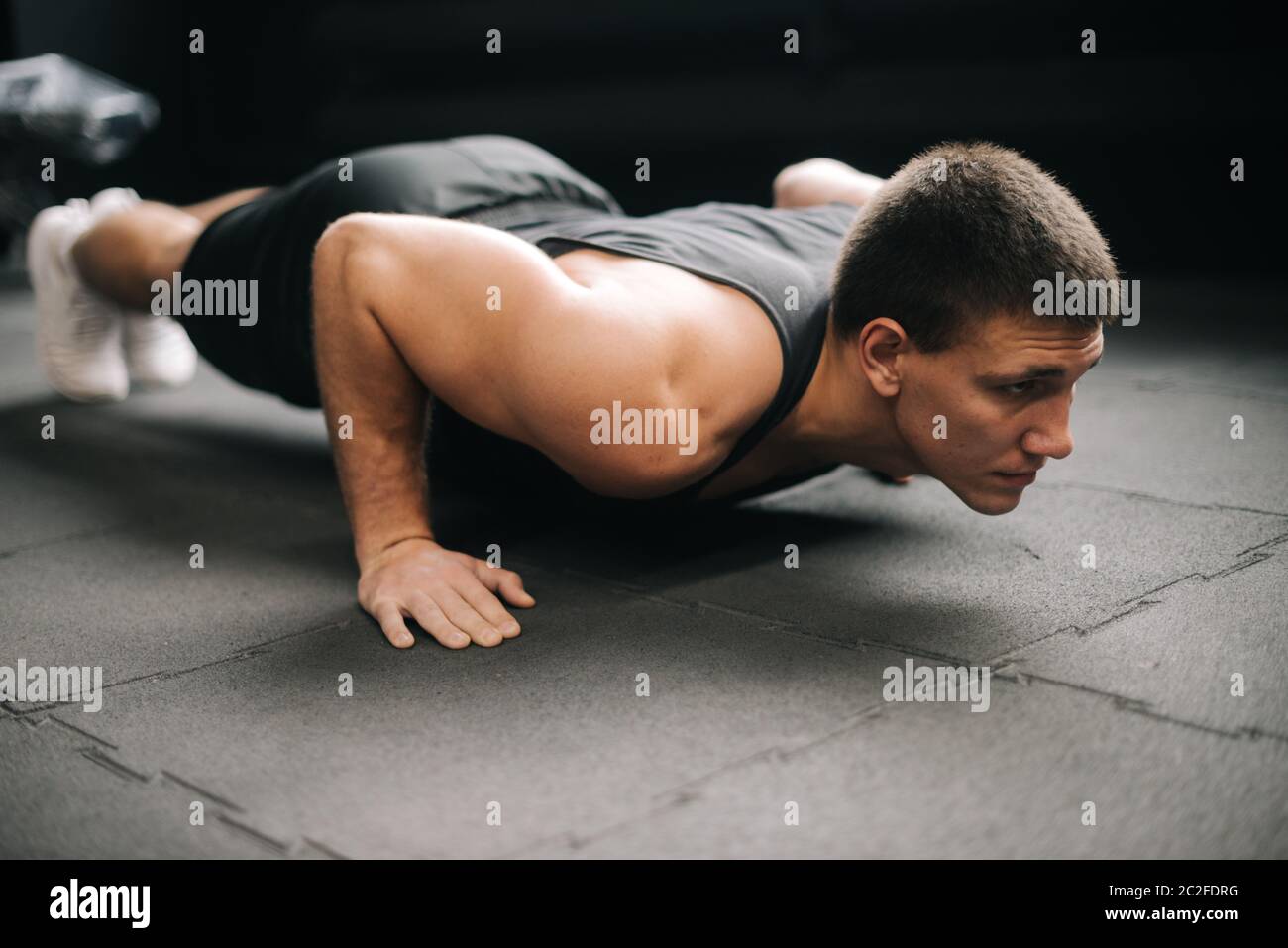 Middle shot portrait of muscular strong man doing push-ups exercise on ...