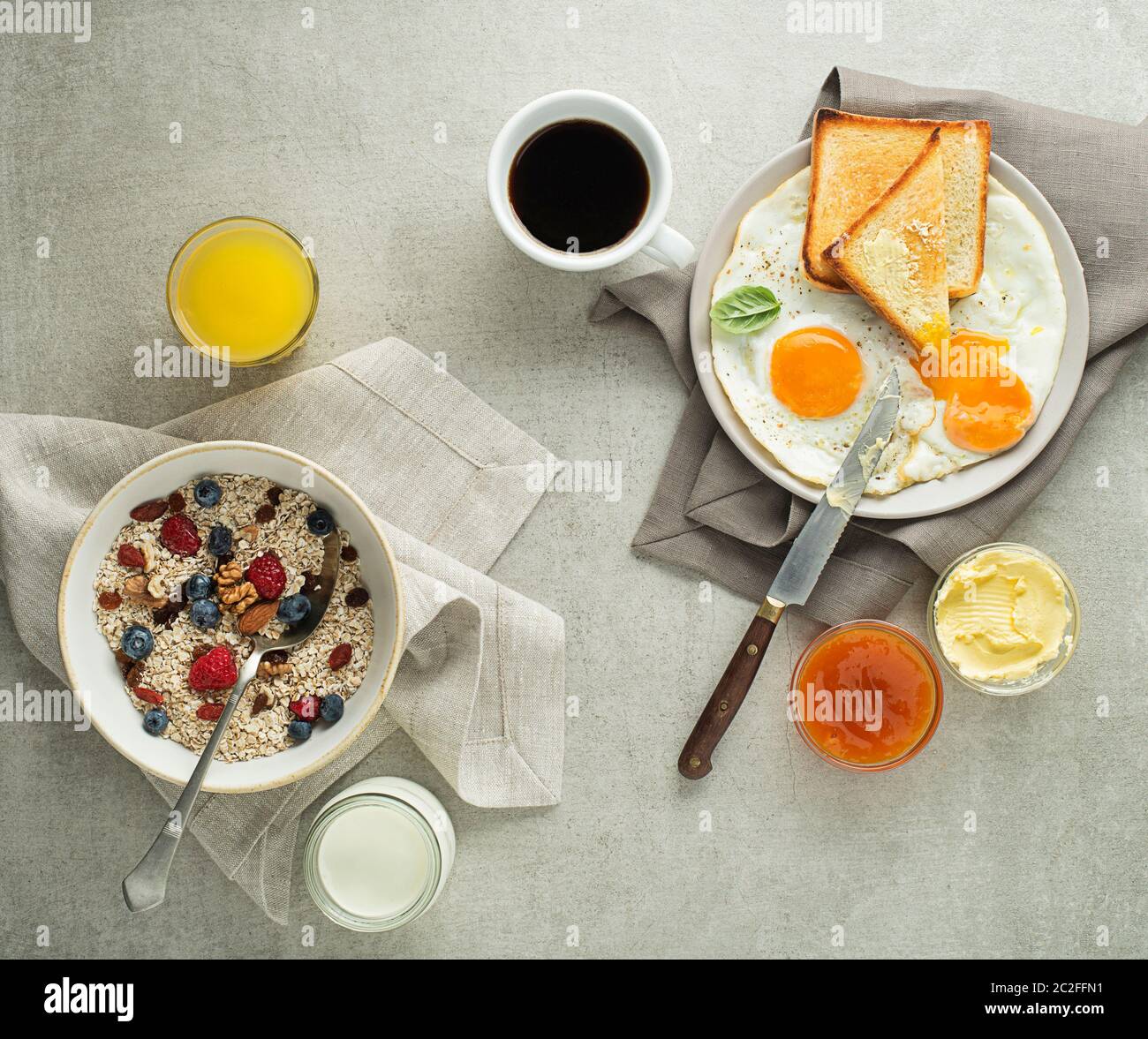 Breakfast served with oatmeal and fruits, fried eggs with bread and jam ...