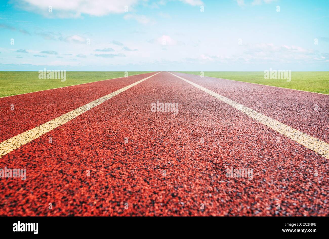 Red running track with sky background Stock Photo - Alamy