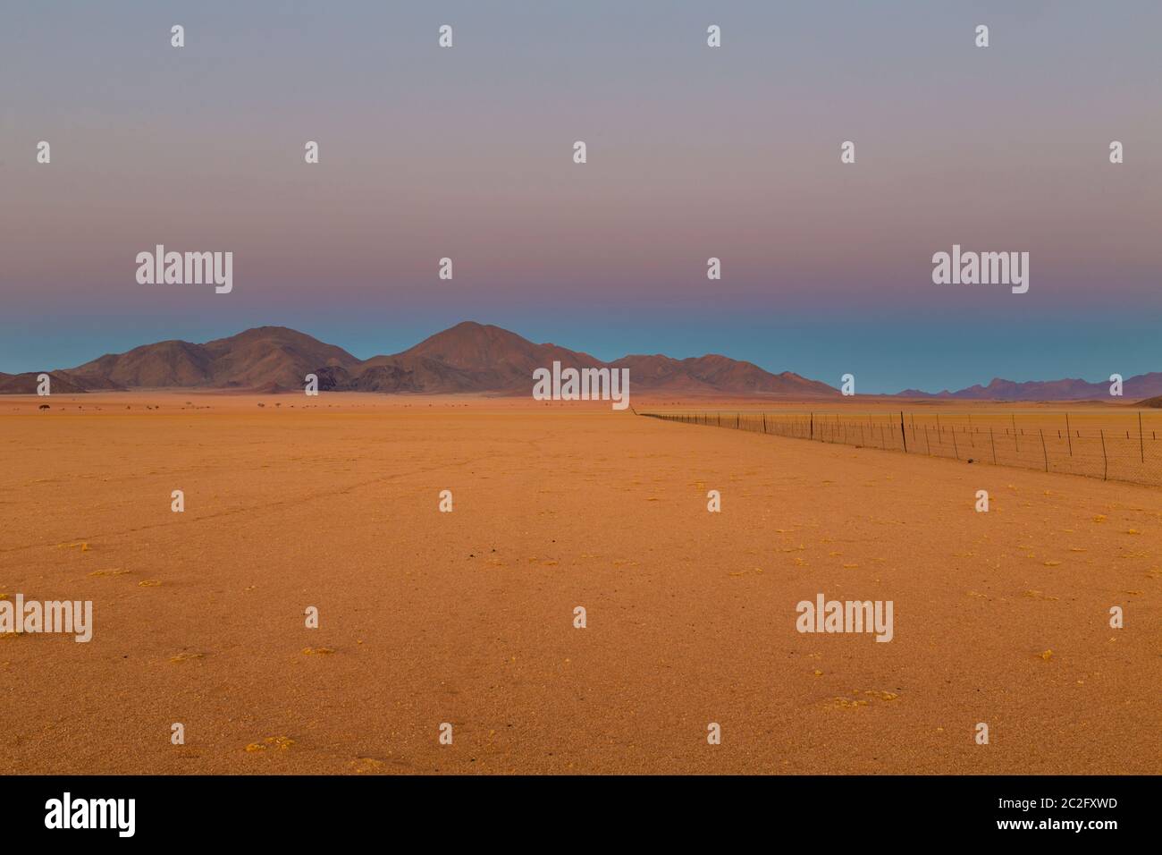 Fence disappearing in the distance in the desert Stock Photo - Alamy