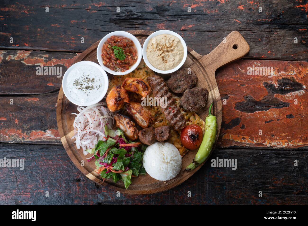 Mixed turkish kebab plate with rice, vegetables and dip sauces isolated ...