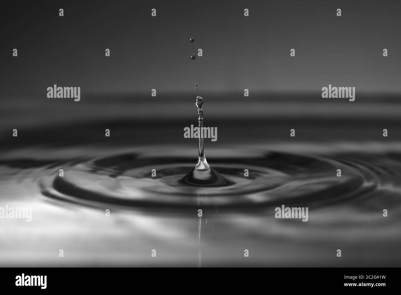 A small water drop fall on water surface Stock Photo - Alamy