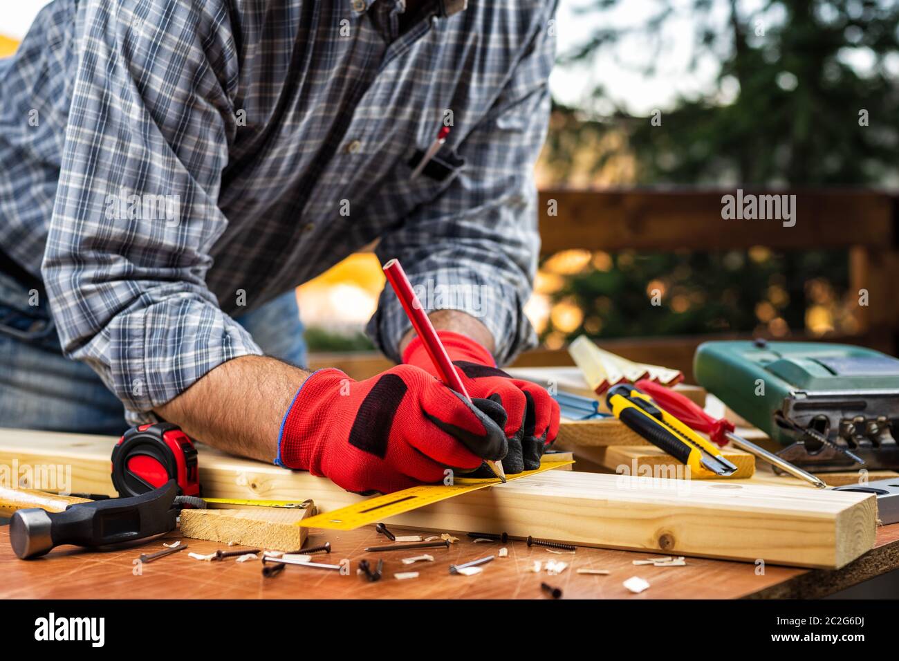 Adult carpenter craftsman wears protective gloves, with a pencil and ...