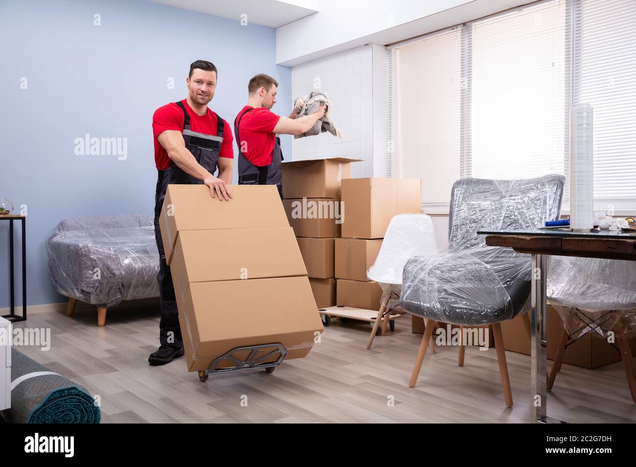 Portrait Of Young Male Mover Packing The Products In The Cardboard ...