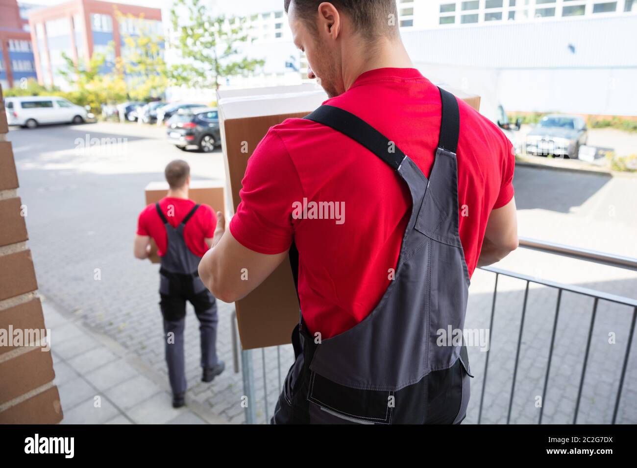 Rear View Of A Men Loading The Brown Cardboard Boxes In Moving Truck ...