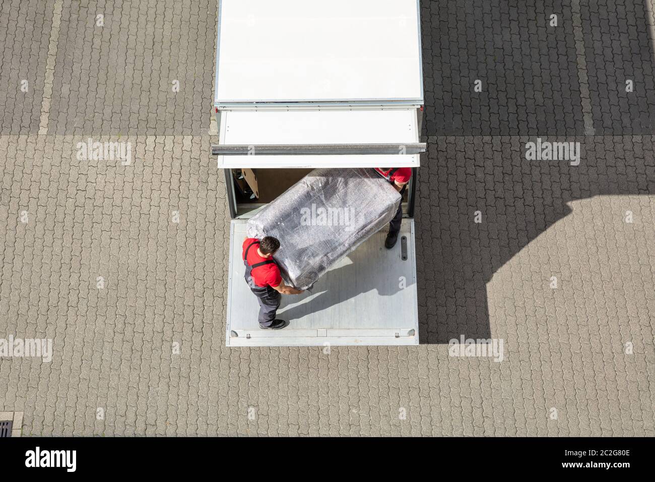 An Elevated View Of Male Mover Unloading The Furniture From Truck On ...