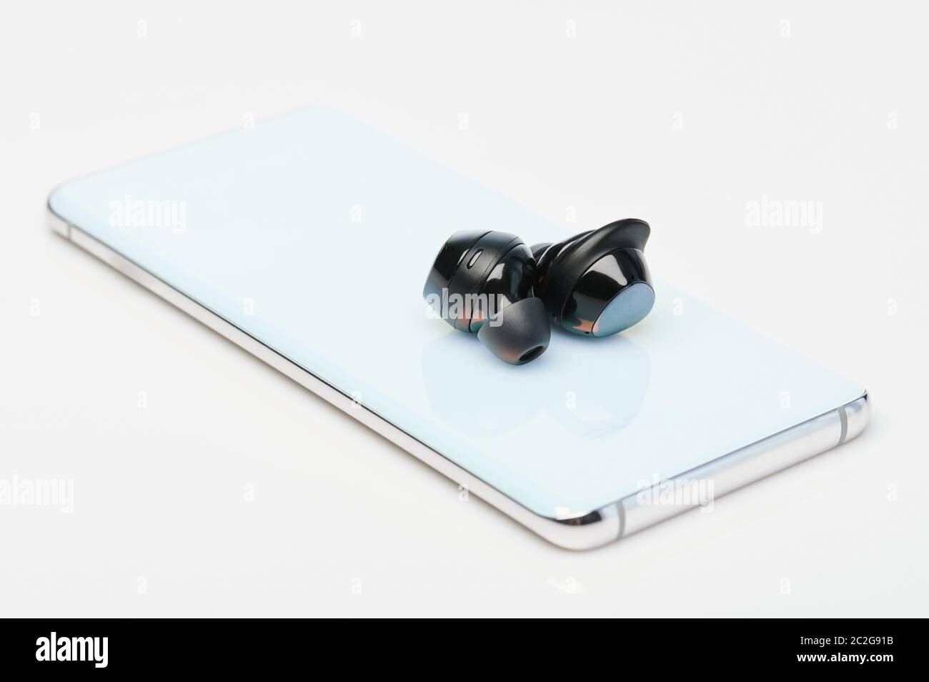Wireless earphones lay on smartphone isolated close up view Stock Photo ...
