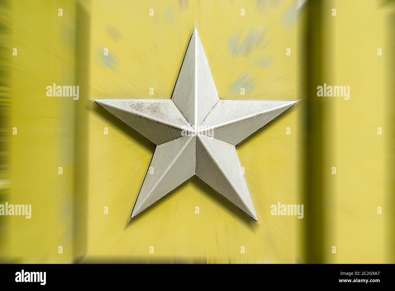 silver metal five pointed Soviet star on a blurred background of light ...