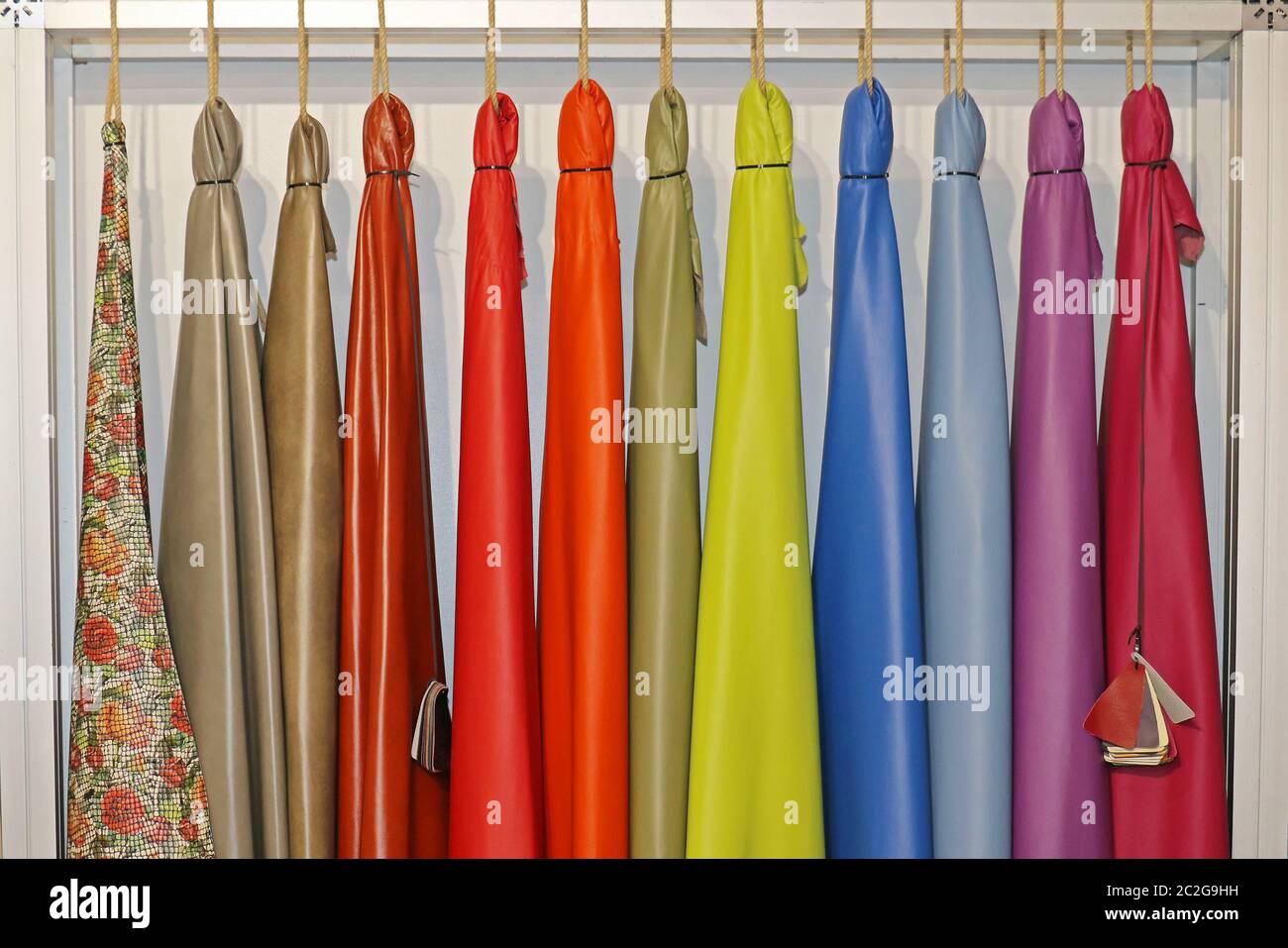 Samples of colorful textile materials hanging on wall Stock Photo - Alamy