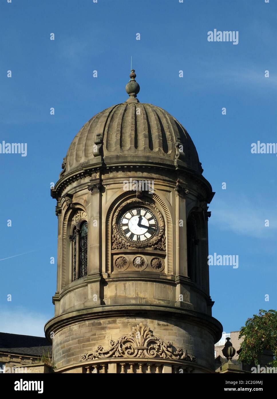 and ornate clock tower with stone cupola against a blue sky on the ...